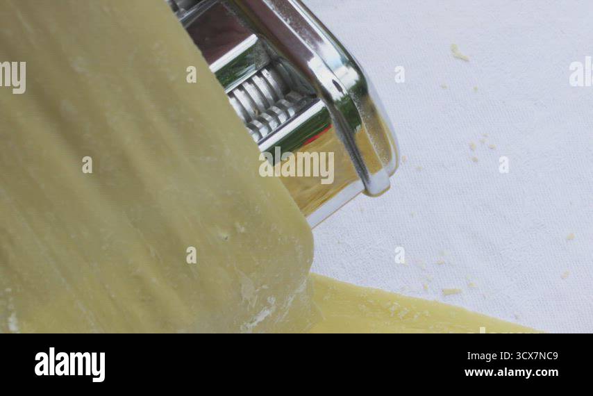 Stretching home made dough on a rolling machine. Preparation of thin ...