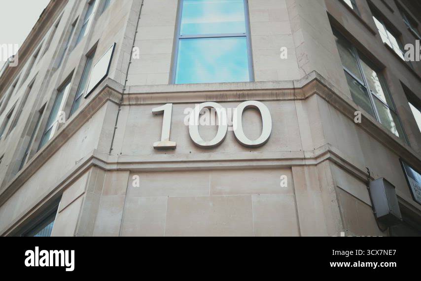 Address number 100 under a window on the corner of a gray building ...
