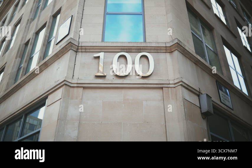 Address number 100 under a window on the corner of a gray building ...