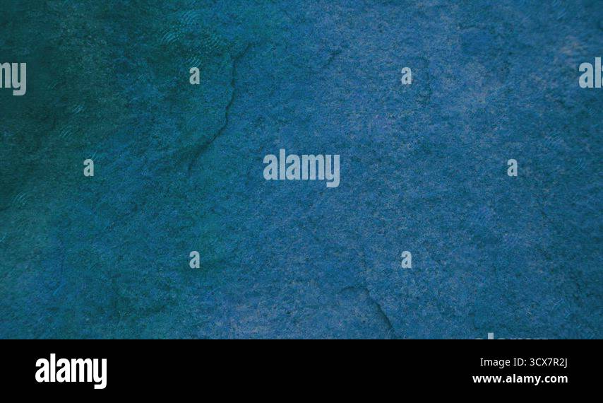 4K rain drop on heavy hard granite dark blue stone surface of cave for ...