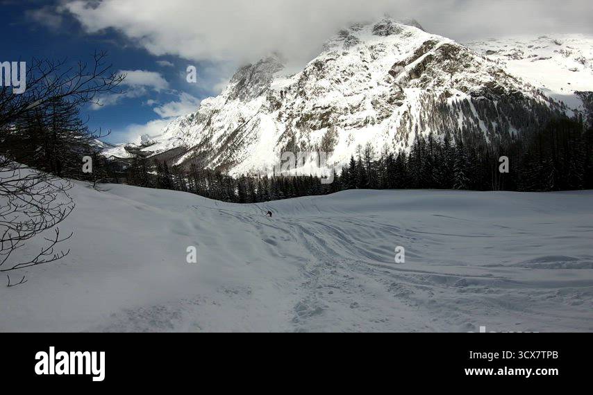 4k UHD bottom POV of snowboarder goes down off piste through the trees ...