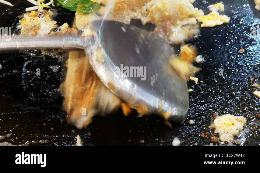 The merchant in street food market are making fried mussels in frying ...