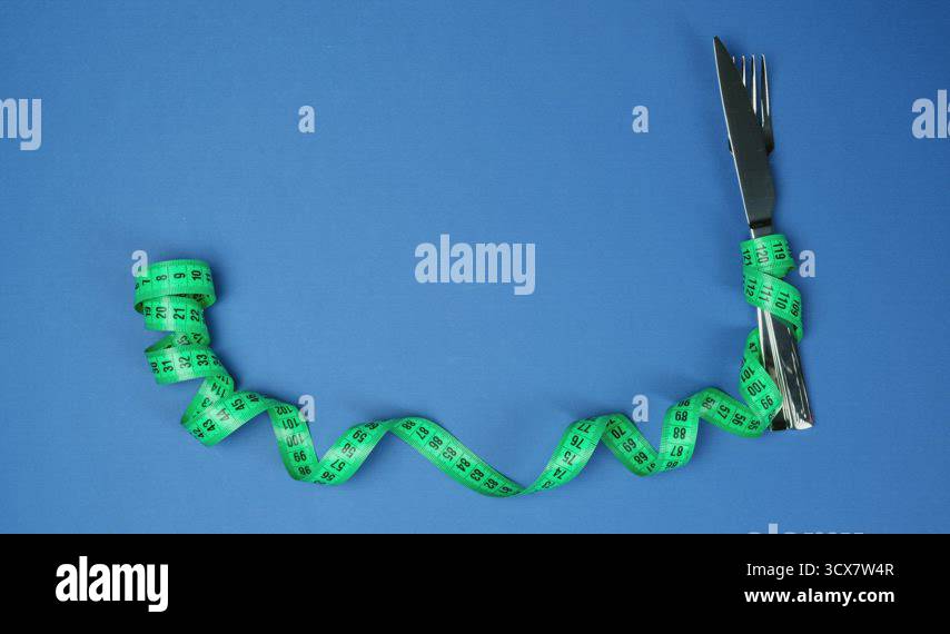 two female hands put a round white plate on a blue surface, a fork and ...