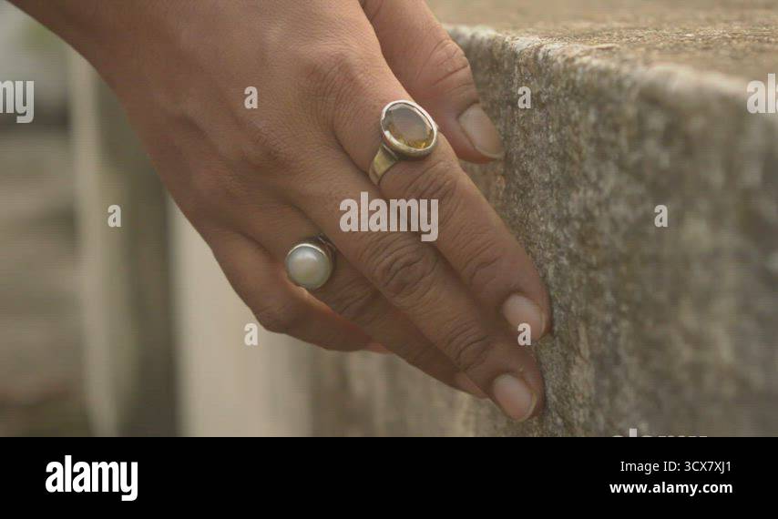 Woman hand touching softly and sliding on the concrete wall on the roof ...