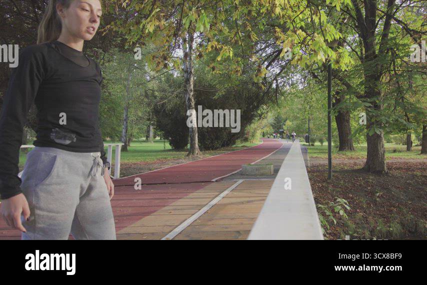 Runner girl stretching her legs on a wooden bridge fence. Clumsy ...