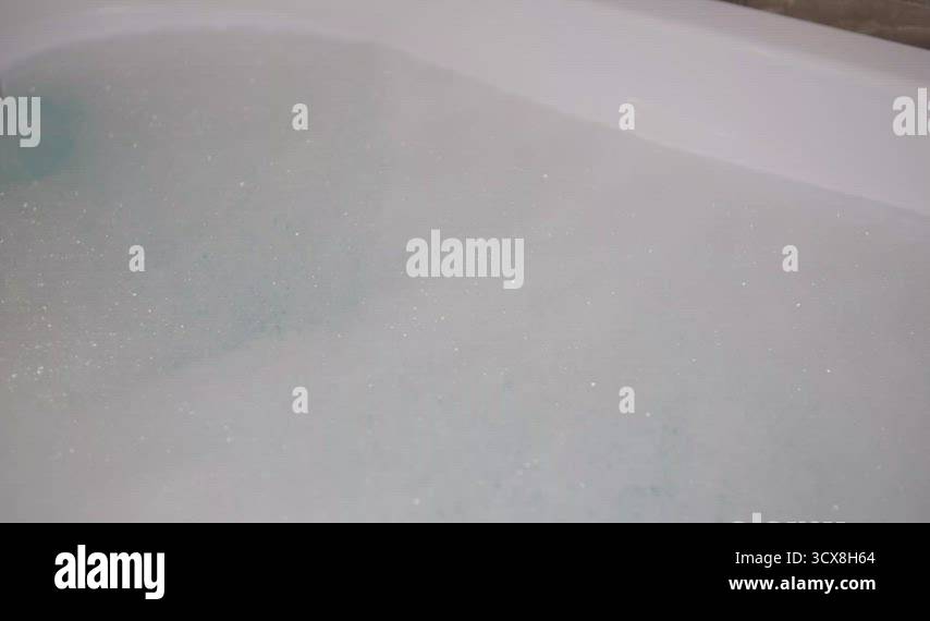 White Foam With Bursting Bubbles. Preparation for taking a bath. Water ...