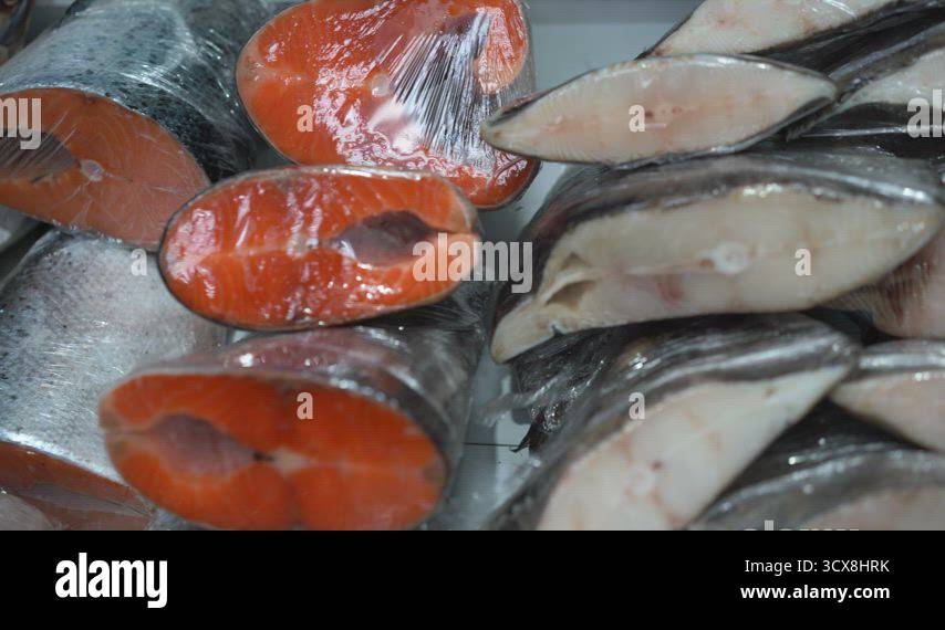 Pieces of red and white fish in a cellophane package on the shop window ...
