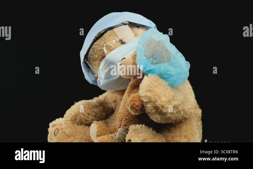 brown teddy bear sits in protective plastic glasses, a medical ...