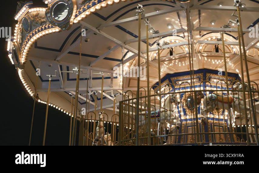 Illuminated merry go round in park. Brightly illuminated roundabout ...