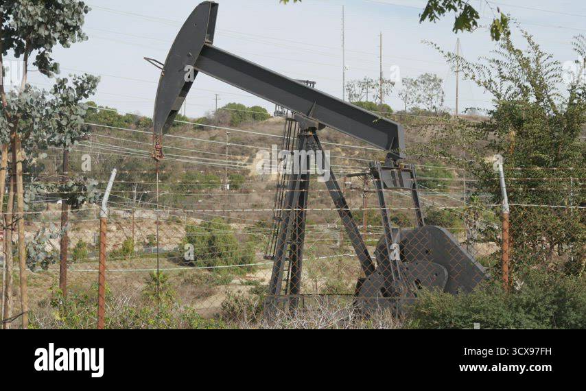 Industrial urban landscape. La Brea Inglewood in Los Angeles. Well pump jack operating behind ...