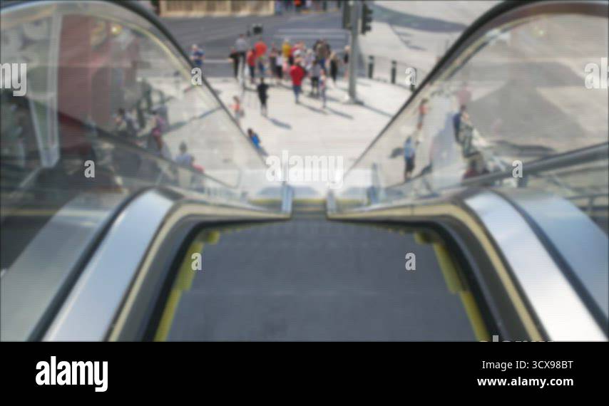 Perspective view thru escalator, defocused unrecognizable group of ...