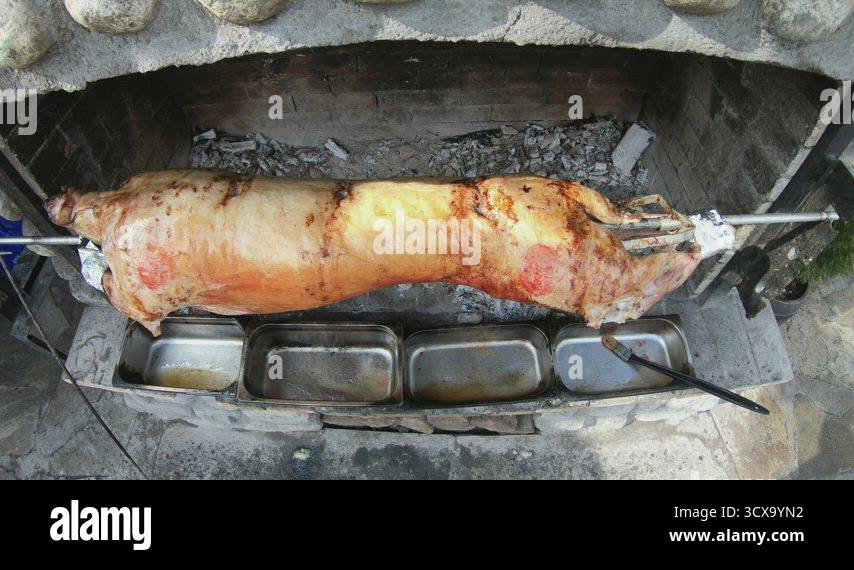 A cook in a restaurant prepares an appetizing roast lamb with a crispy ...