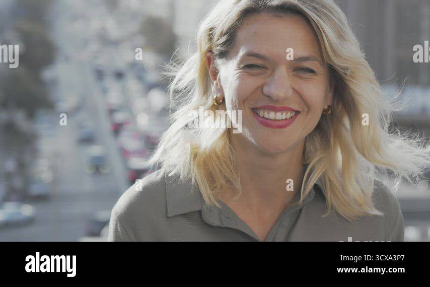 Charming mature happy woman laughing to the camera on urban background ...
