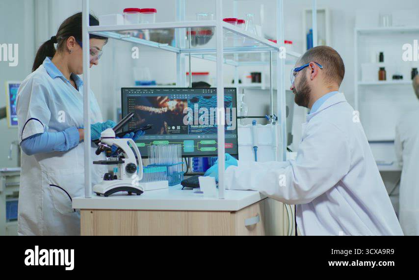 Team of medical researcher conducting experiments using test tubes ...