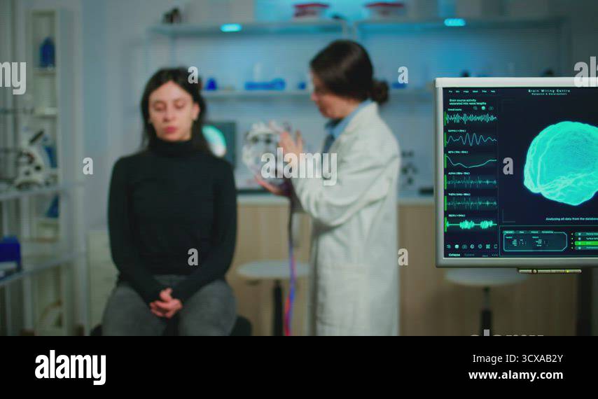 Medical lab technician adjusting eeg headset monitoring brain functions ...