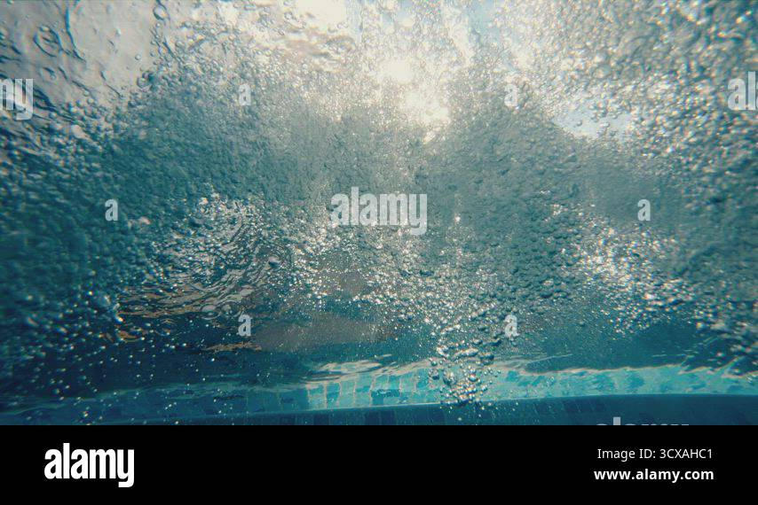 Air bubbles in a pool and sunrays reflecting in the water surface Stock ...