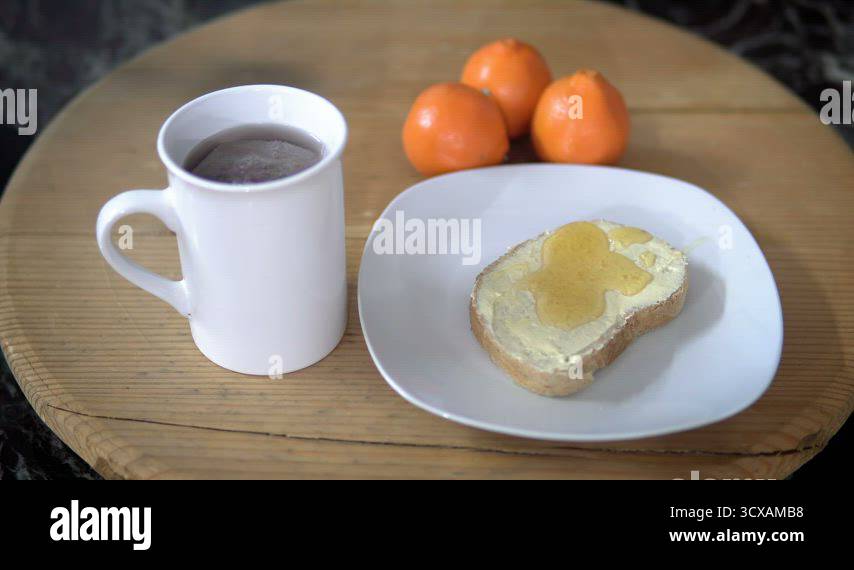 Pouring snacks over a slice of bread with butter and honey. Food ...