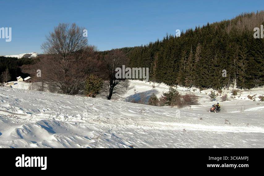 Sport yellow snowmobile jump in slow motion. Cloud of snow dust from ...