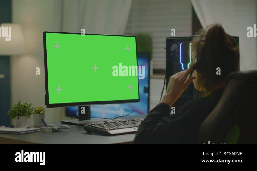 Pro gamer playing virtual video game on computer with green screen ...