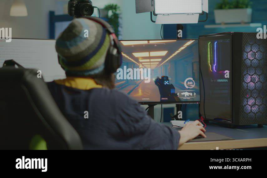 Back shot of pro streamer with headphone playing FPS videogame Stock ...