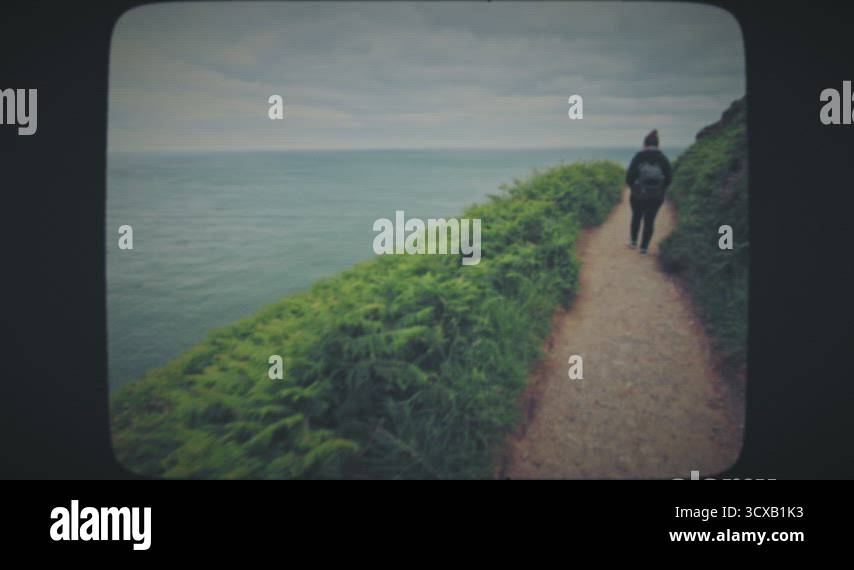 Woman walking along the cliff near ocean Stock Video Footage - Alamy