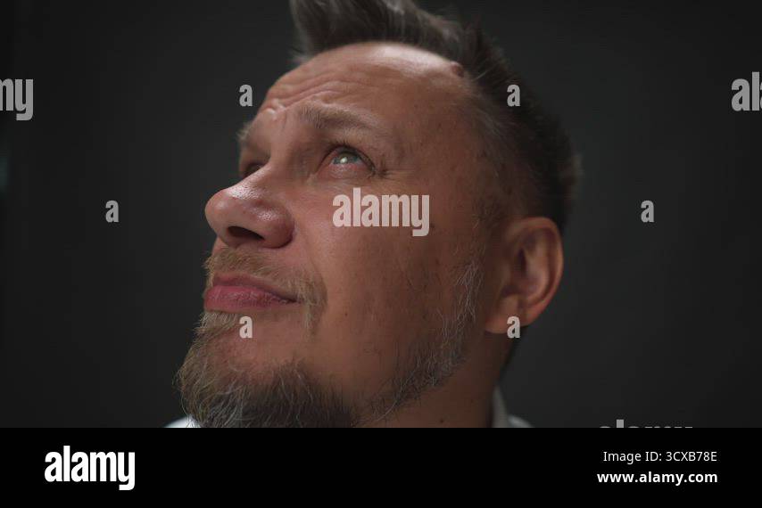 Super close-up of the head of a man with no confidence and looks up ...