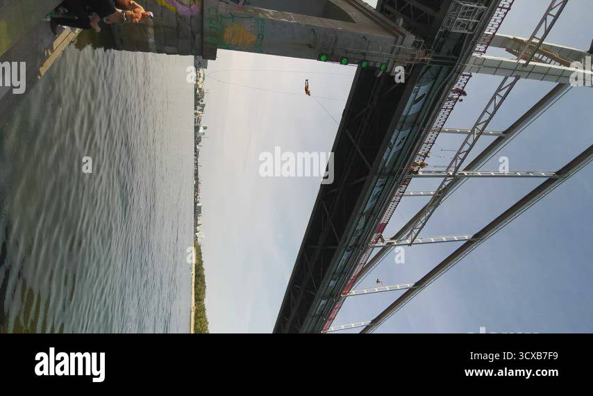 Vertical footage of Dnipro river with pedestrian bridge overlooking the ...