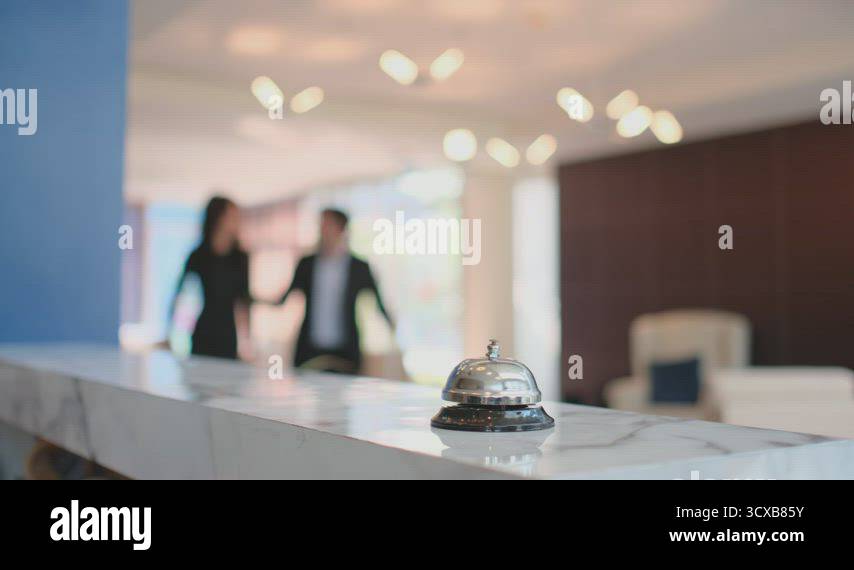 Main focus on bell on front desk of hotel lobby then beautiful ...