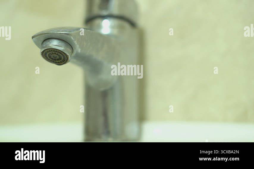 Water dripping from the tap close-up. Scheduled water shutdown and ...
