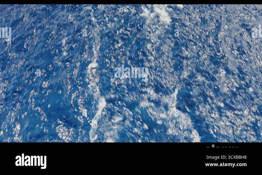 Raging stream of sea water from under boat at sunny weather, slow ...