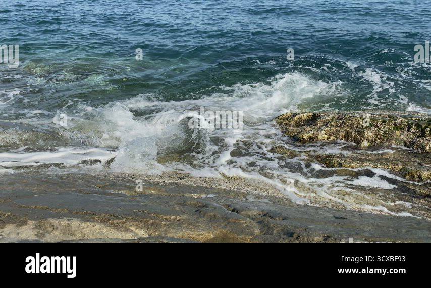 Transparent sea waves lapping on the rock Stock Video Footage - Alamy
