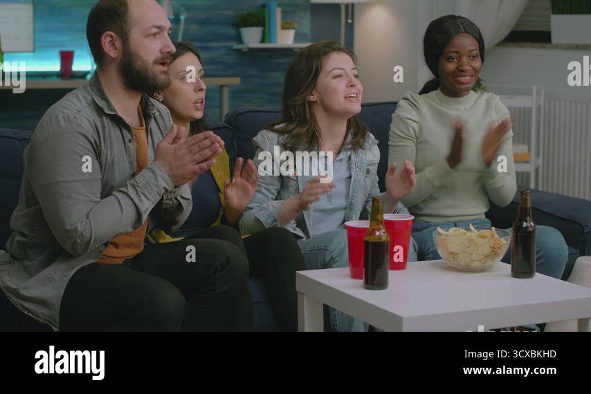 Mixed race people cheering together while looking at soccer Stock Video ...