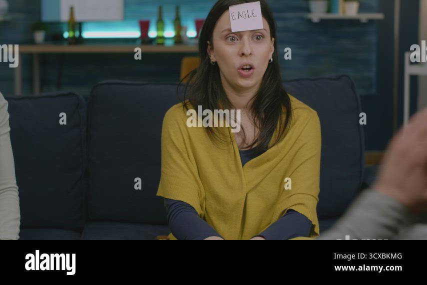 Funny multi-ethnic friends with sticky notes on forehead enjoying guess ...