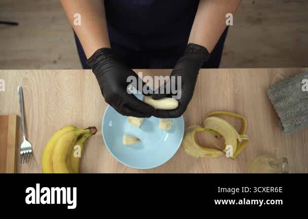 Woman Smashing sliced bananas on a plate. mother cooking food for baby ...