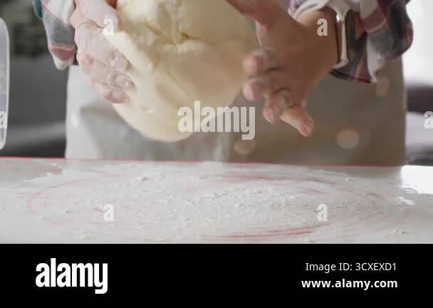 The process of making homemade bread. A cook's hands sprinkle flour on ...