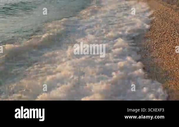Crystal clear Adriatic sea waves gently wash over a beautiful pebble ...