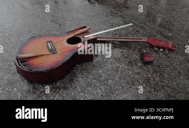 Broken guitar on the ground in snowy rain falling on it. Rage quit ...