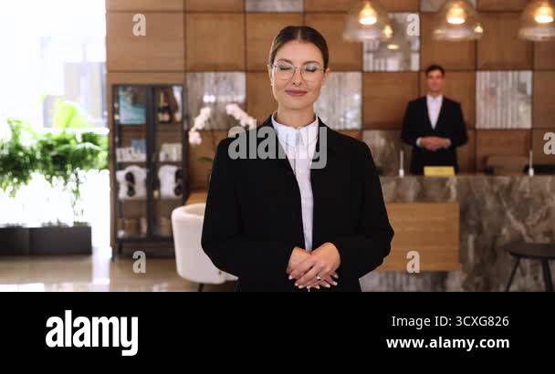 Portrait of smiling Hispanic female hotel receptionist gesturing ...