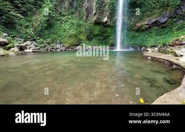 Point of view of huge tropical waterfall and lagoon, clear blue waters ...