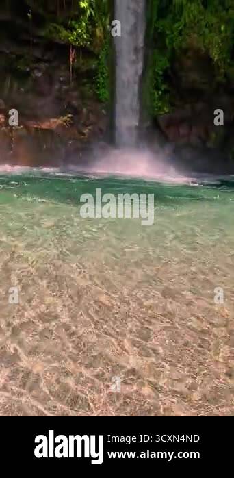 Point of view of huge tropical waterfall and lagoon, clear blue waters ...