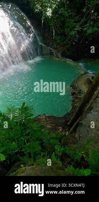 Point of view of huge tropical waterfall and lagoon, clear blue waters ...
