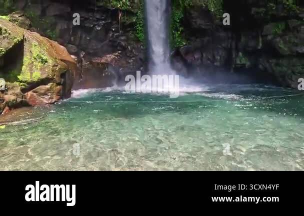 Point of view of huge tropical waterfall and lagoon, clear blue waters ...