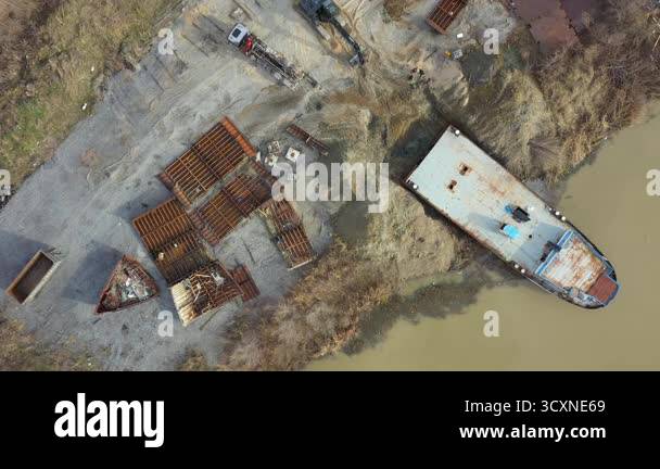 Above view on workers as cutting parts of old large vessel into smaller ...