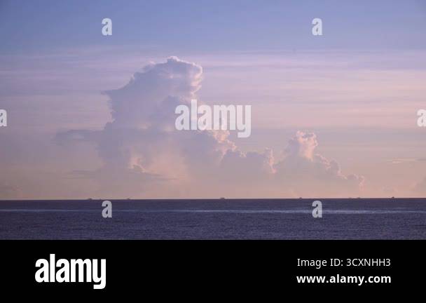 An unusual and towering cumulus cloud formation rises above the ocean ...