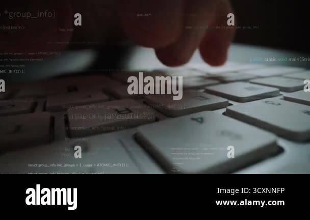 A close-up image of hands typing on a keyboard, with programming code ...