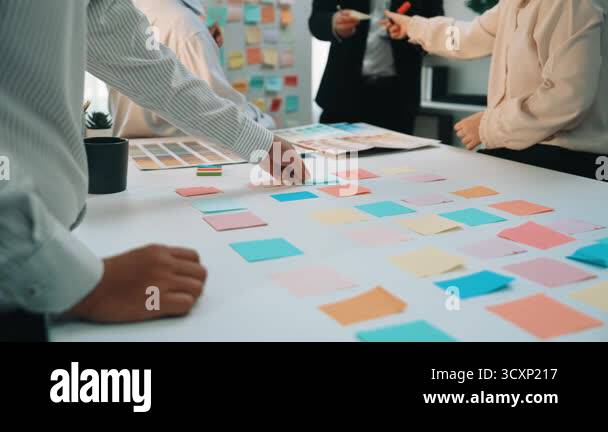 A dynamic office scene showing a diverse group of professionals engaged in a brainstorming ...