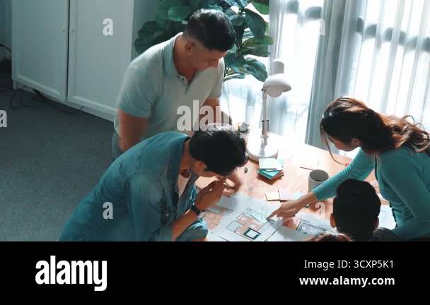 Top view of smart civil engineer looking project plan at meeting table while design building ...