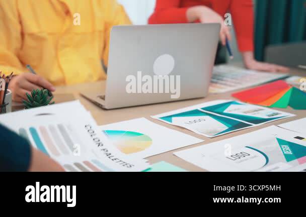 Professionals analyze color palettes in a modern workspace, showcasing ...