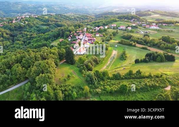 A small cozy village with cute houses and paved roads in a valley with ...