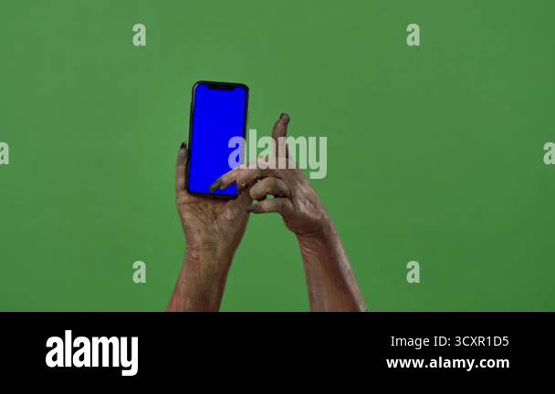 Creepy zombie hands holding a smartphone with a blue screen, covered in ...
